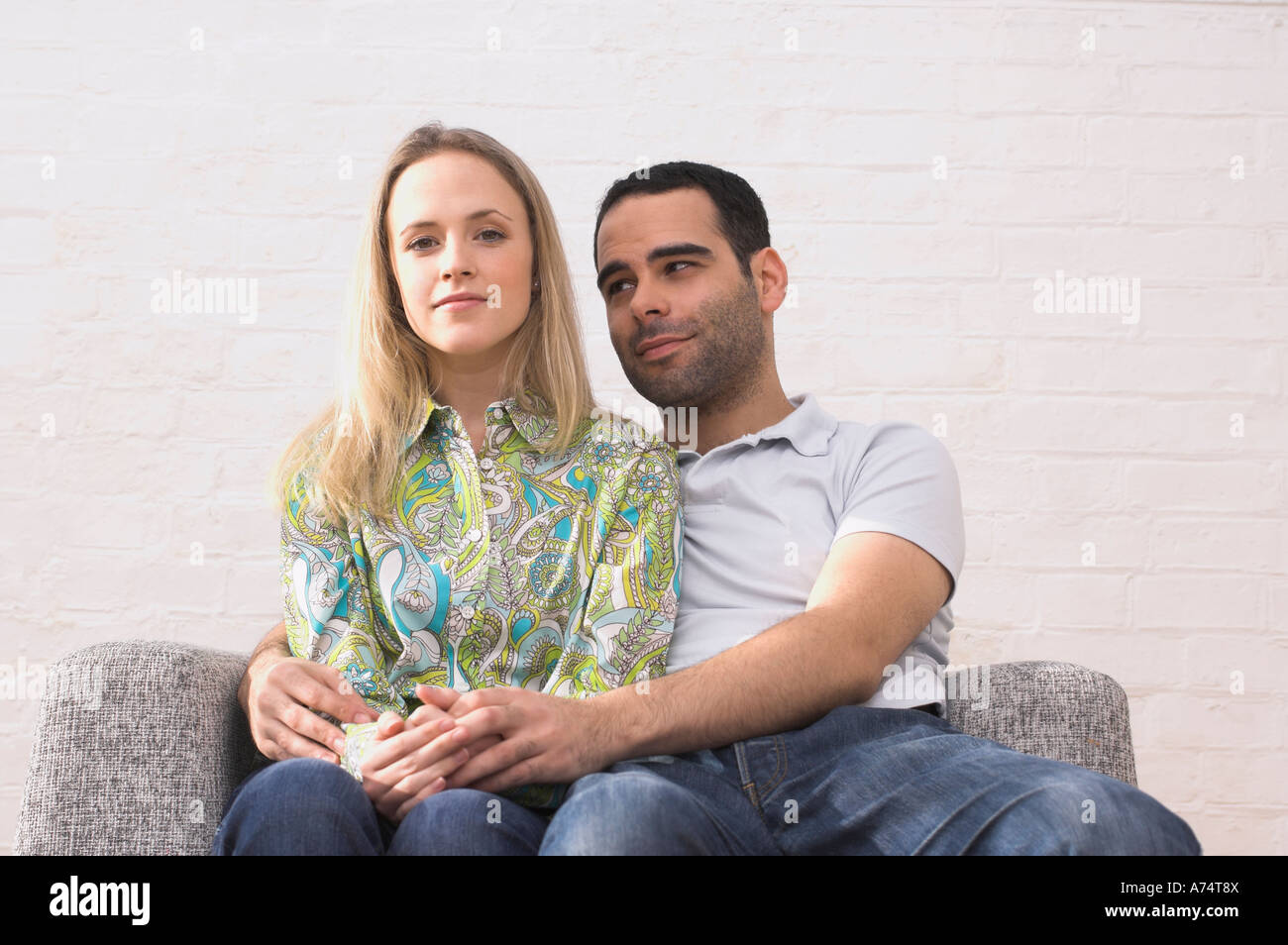 young couple sitting on armchair man tenderly embracing woman Stock ...