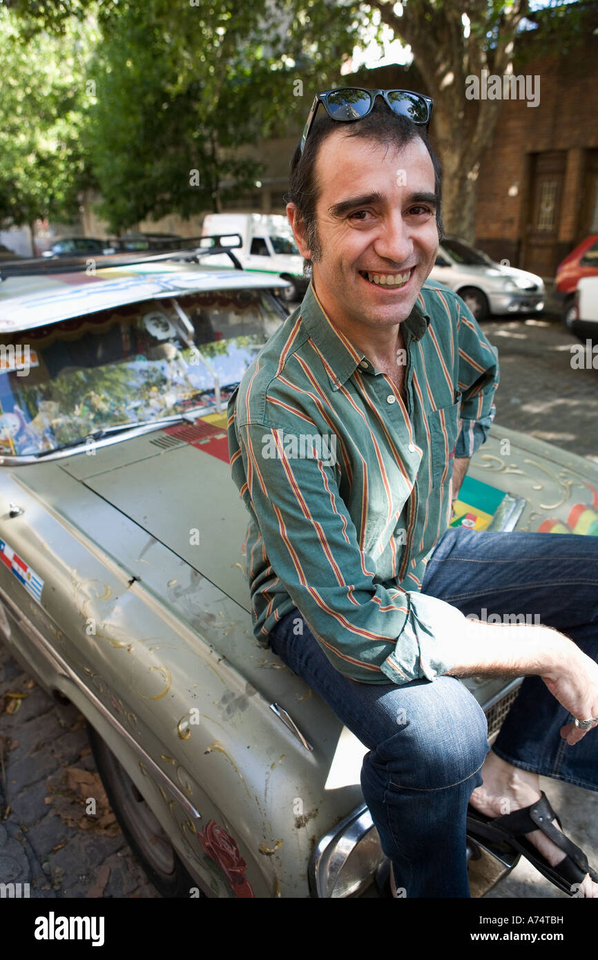 Man sitting on car hood Stock Photo - Alamy