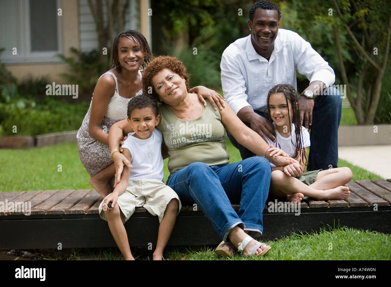 Family smiling in backyard Stock Photo - Alamy