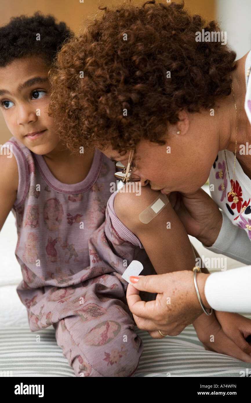 Middle-aged woman applying bandage to grandson Stock Photo - Alamy