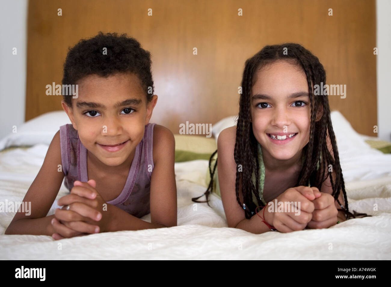 Siblings laying on bed Stock Photo - Alamy