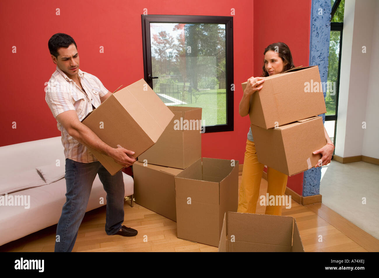 Couple carrying cardboard boxes Stock Photo - Alamy