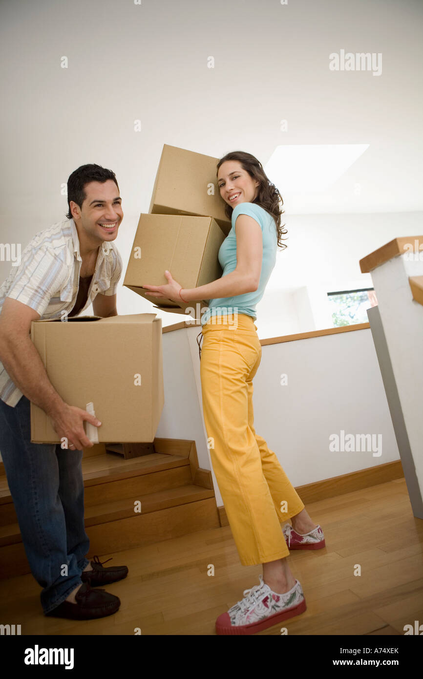 Couple carrying cardboard boxes Stock Photo - Alamy