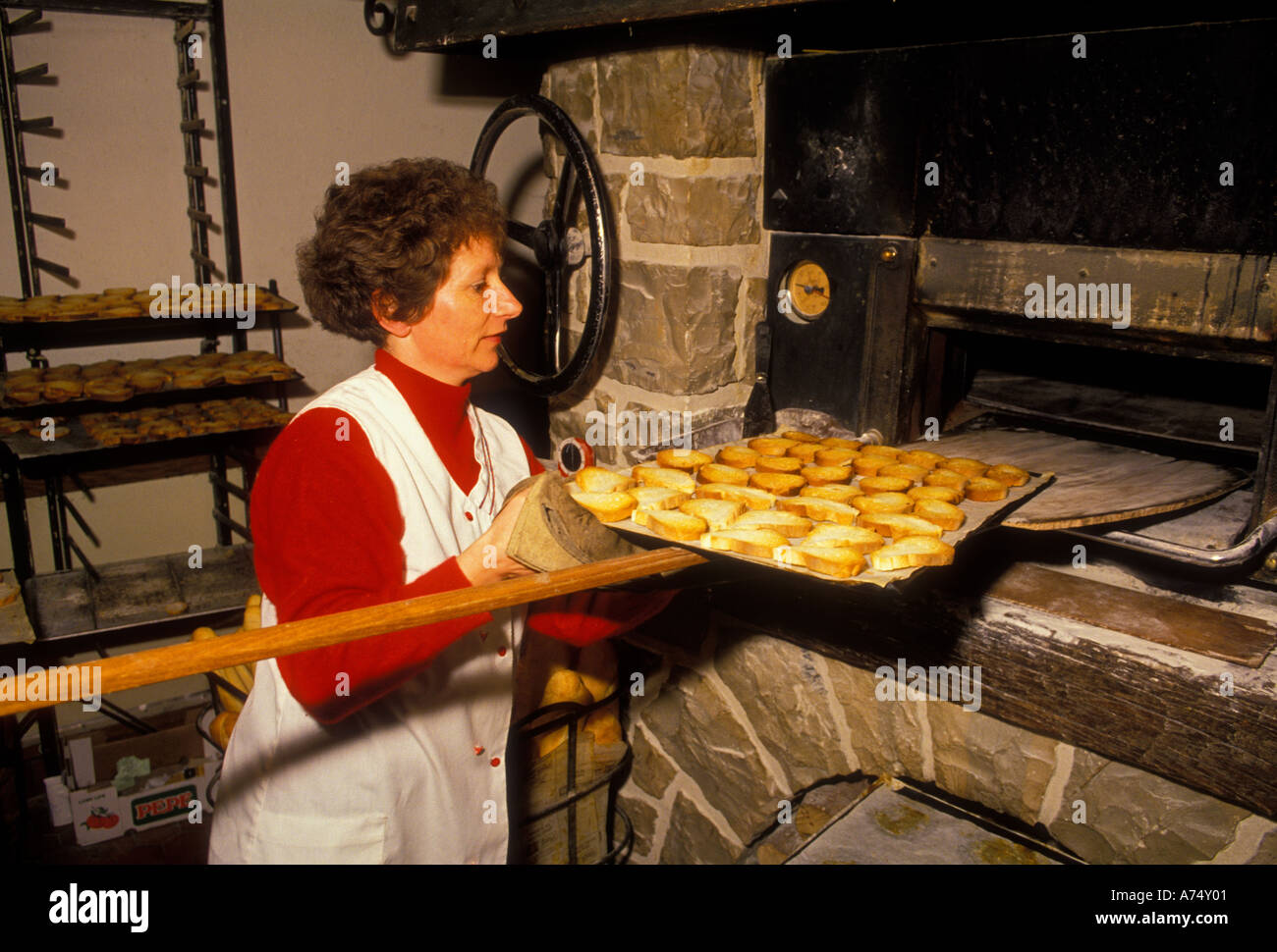 1, one, French Basque woman, baker, putting sliced bread into oven ...
