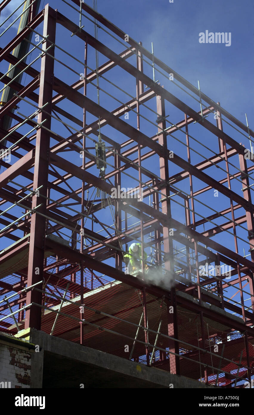 Urban construction worker on steel framed building working on an inner ...