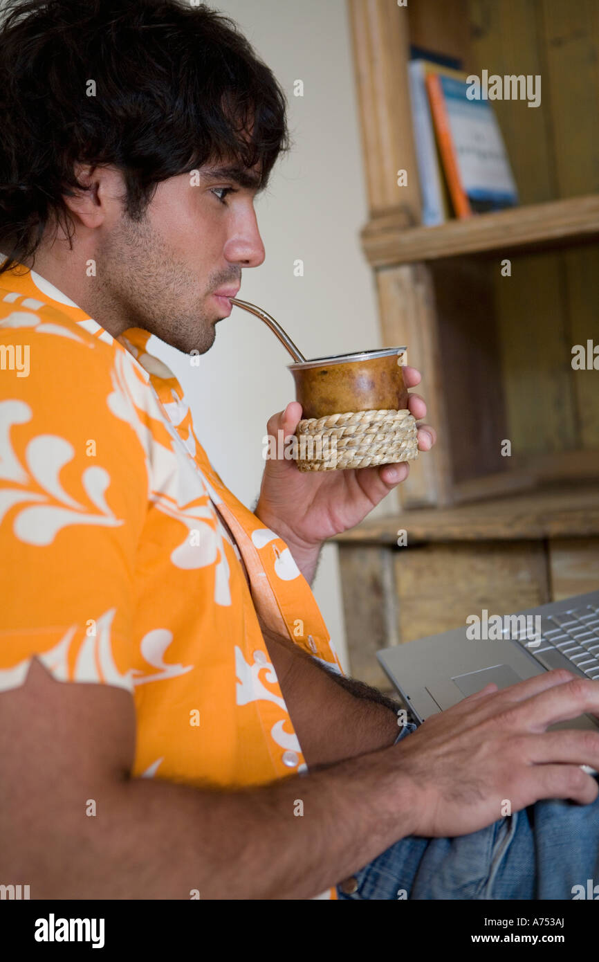 Man drinking while using a laptop Stock Photo - Alamy