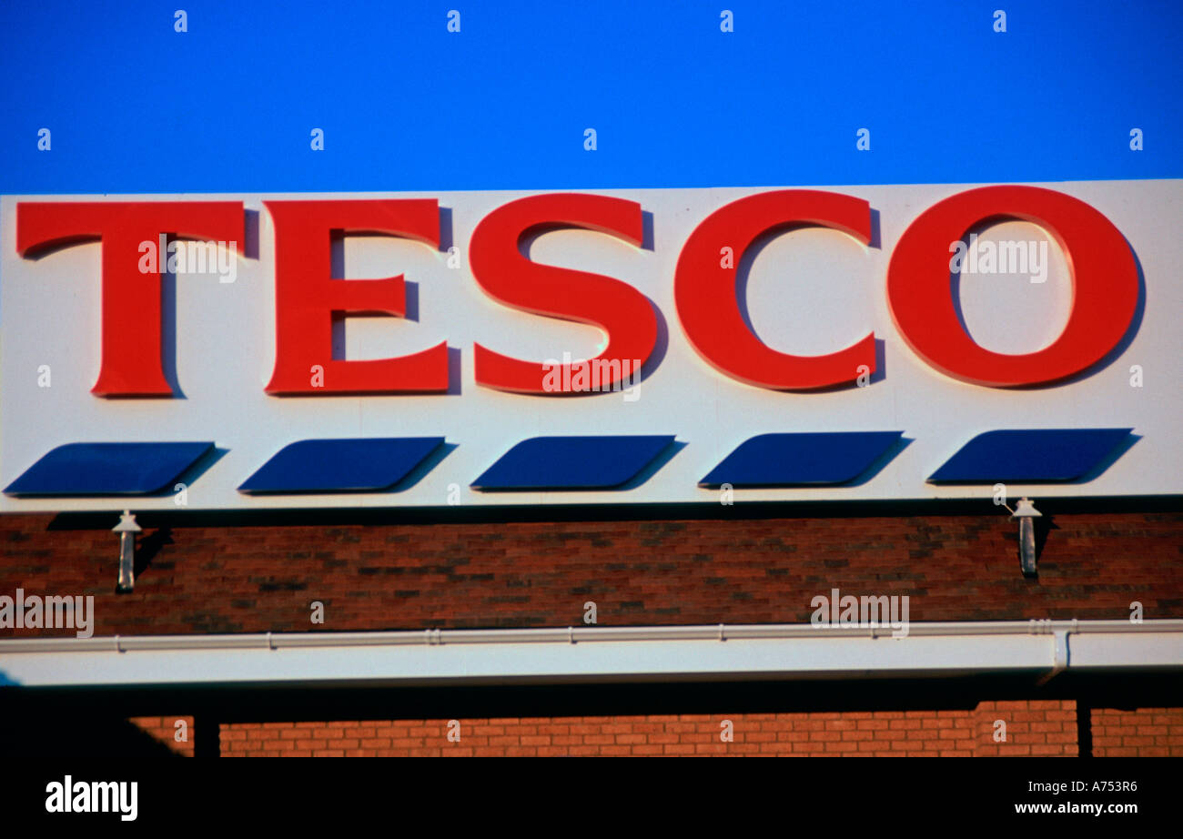 Large red Tesco sign on building with blue sky Stock Photo - Alamy