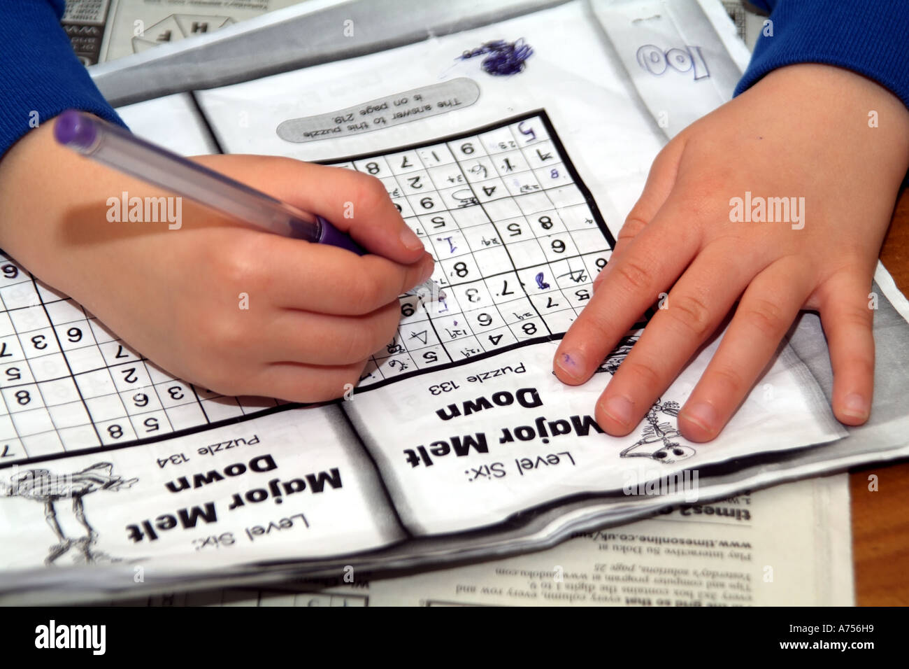 Su Doku sudoku Child's hands completing and solving this popular puzzle ...