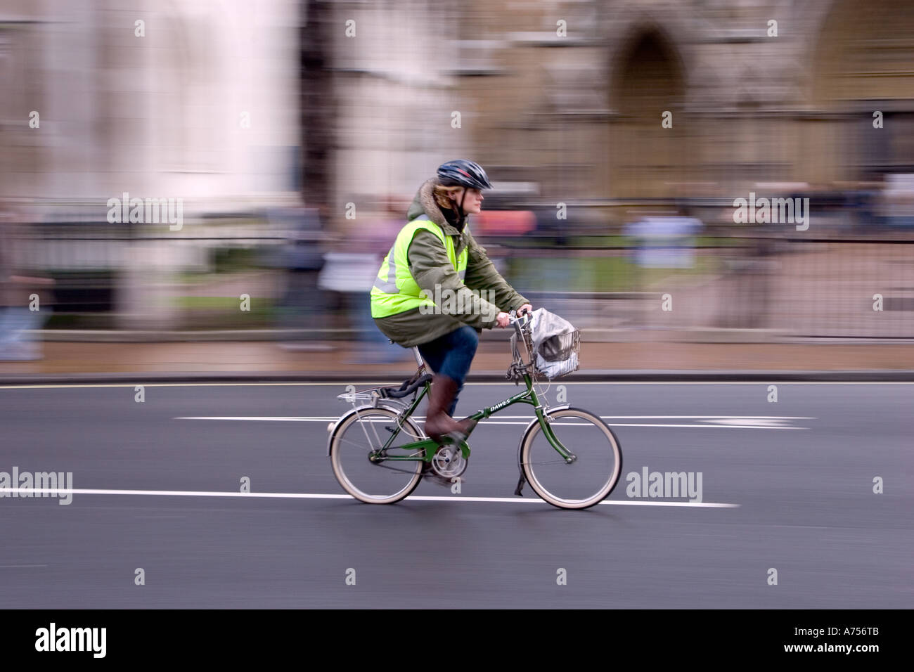 A commuter on a fold up cycle in the city centre London motion blur ...