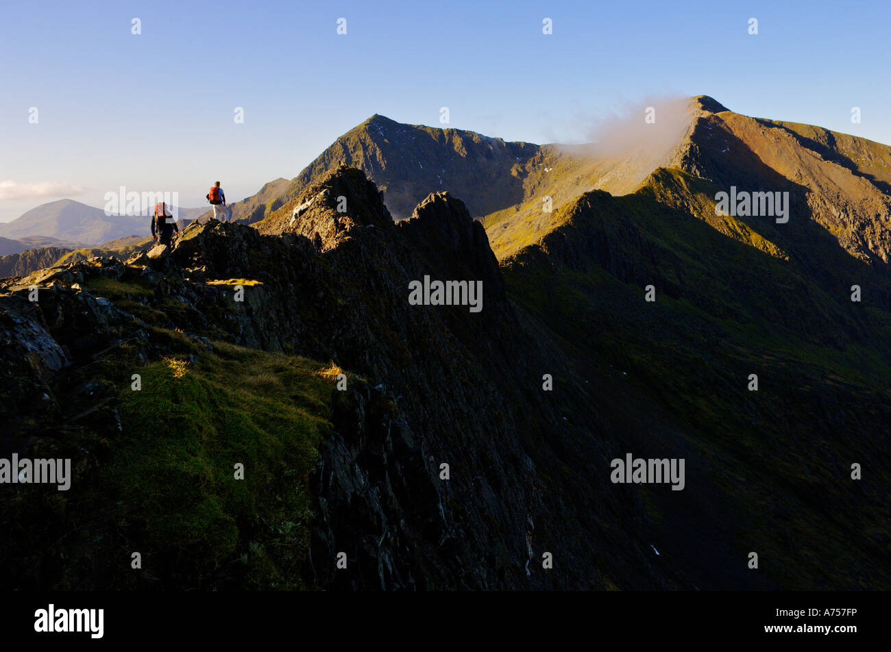 Two walkers on the Crib Goch ridge with Snowdon in the distance ...