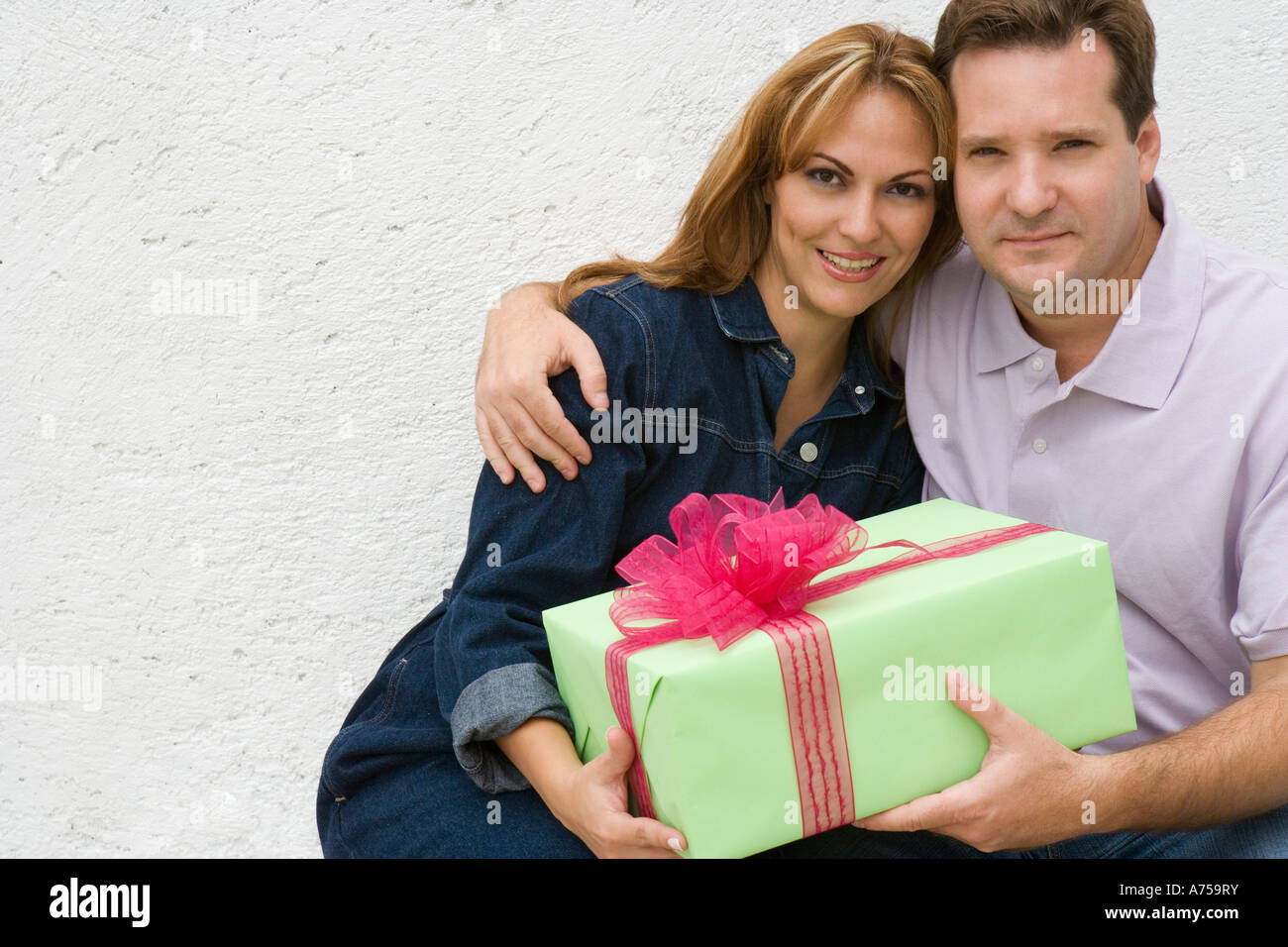 Young couple holding a present Stock Photo - Alamy