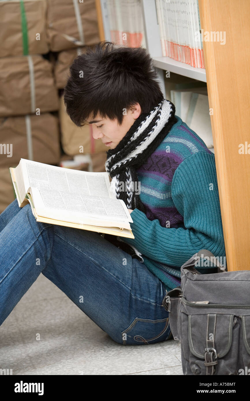 Man reading book in bookstore Stock Photo - Alamy
