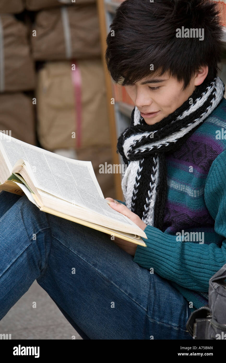 Man reading book in bookstore Stock Photo - Alamy