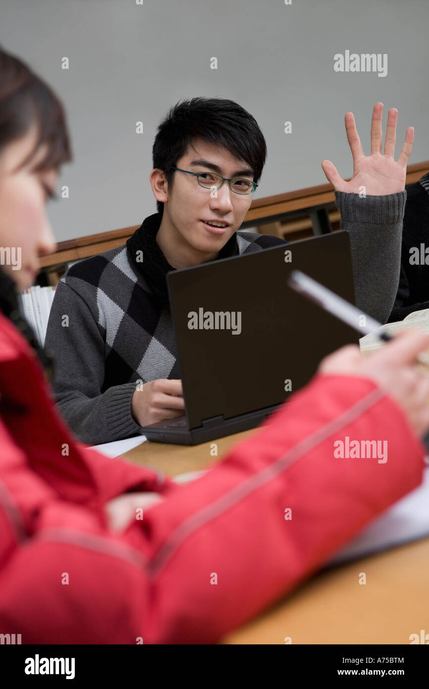 Male student saluting while studying Stock Photo - Alamy