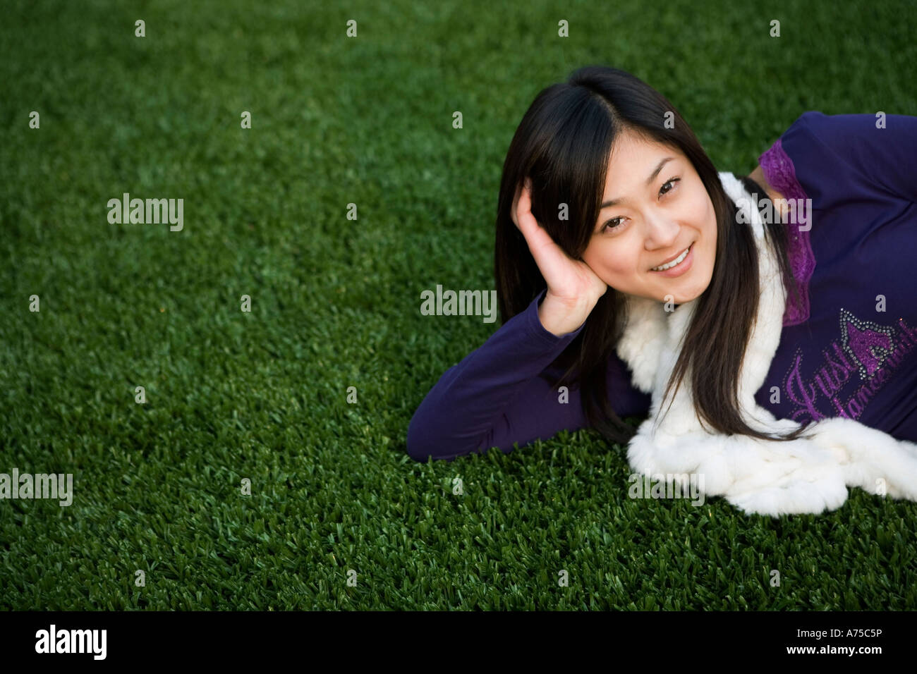 Woman laying on grass Stock Photo - Alamy