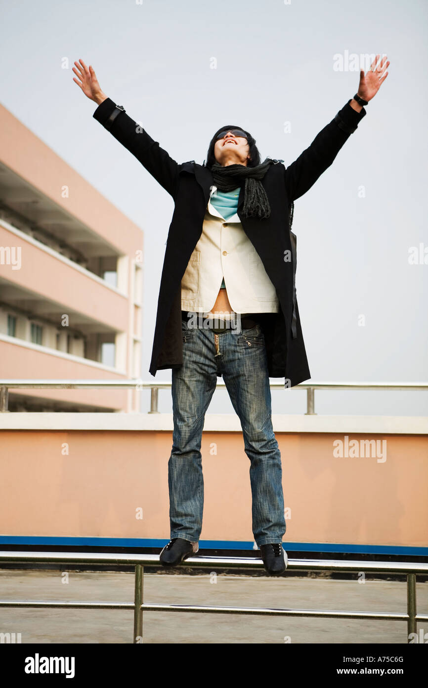 Man balancing on metal railing Stock Photo - Alamy
