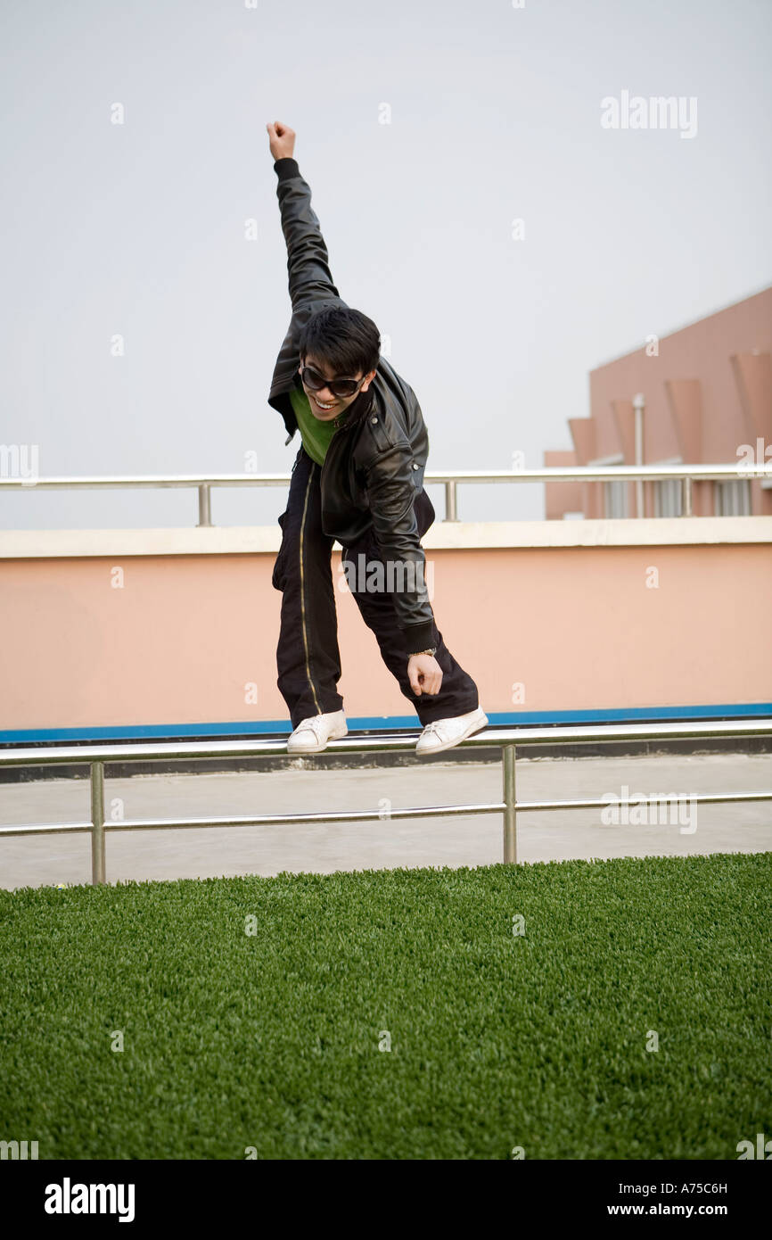 Man balancing on metal railing Stock Photo - Alamy