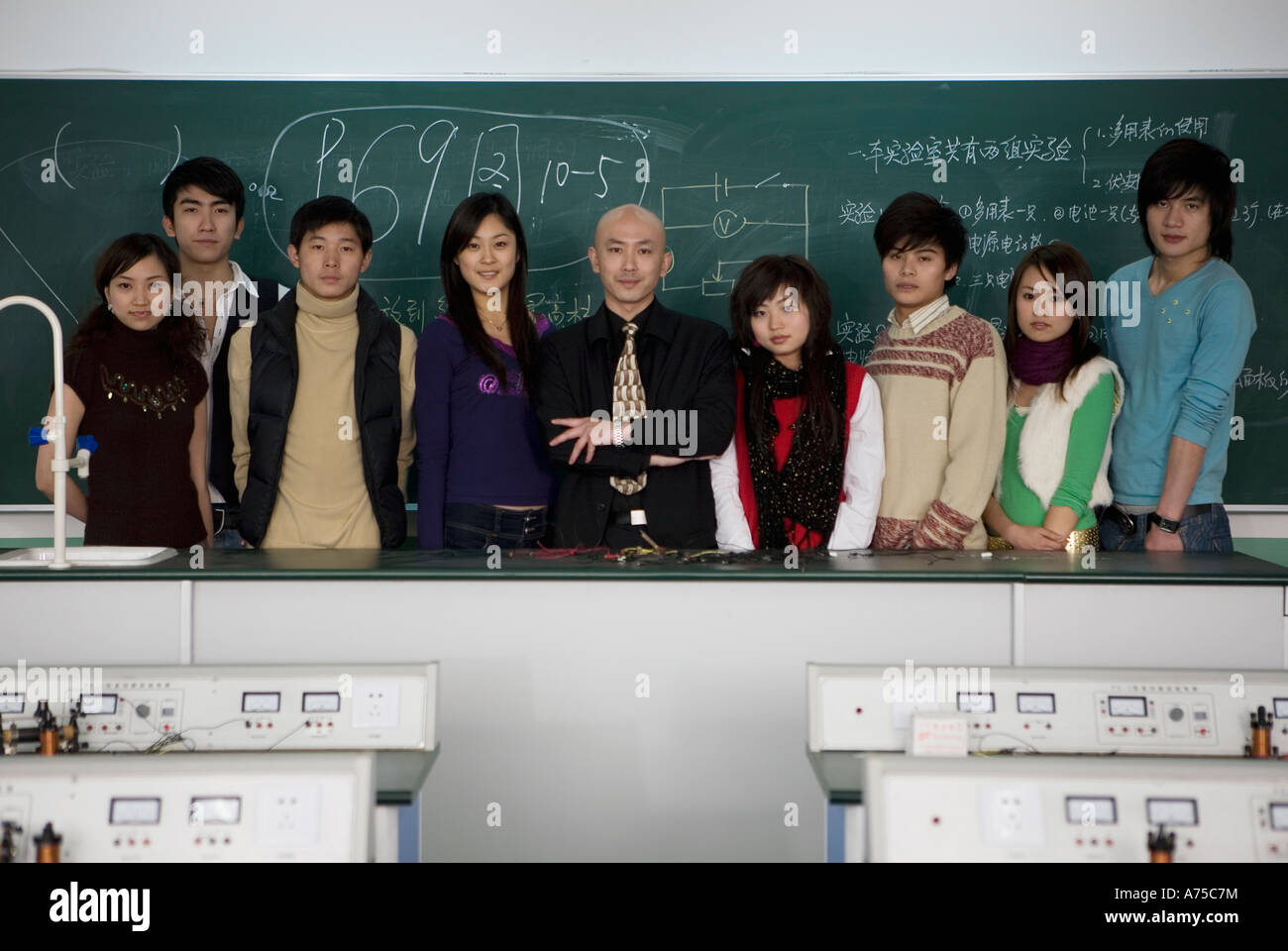 Teacher and class standing at chalkboard Stock Photo - Alamy