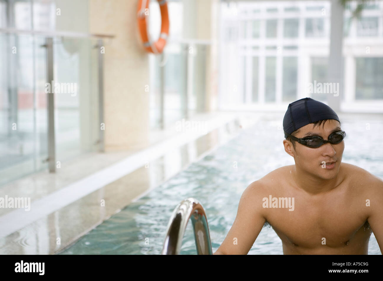 Man climbing out of swimming pool Stock Photo - Alamy