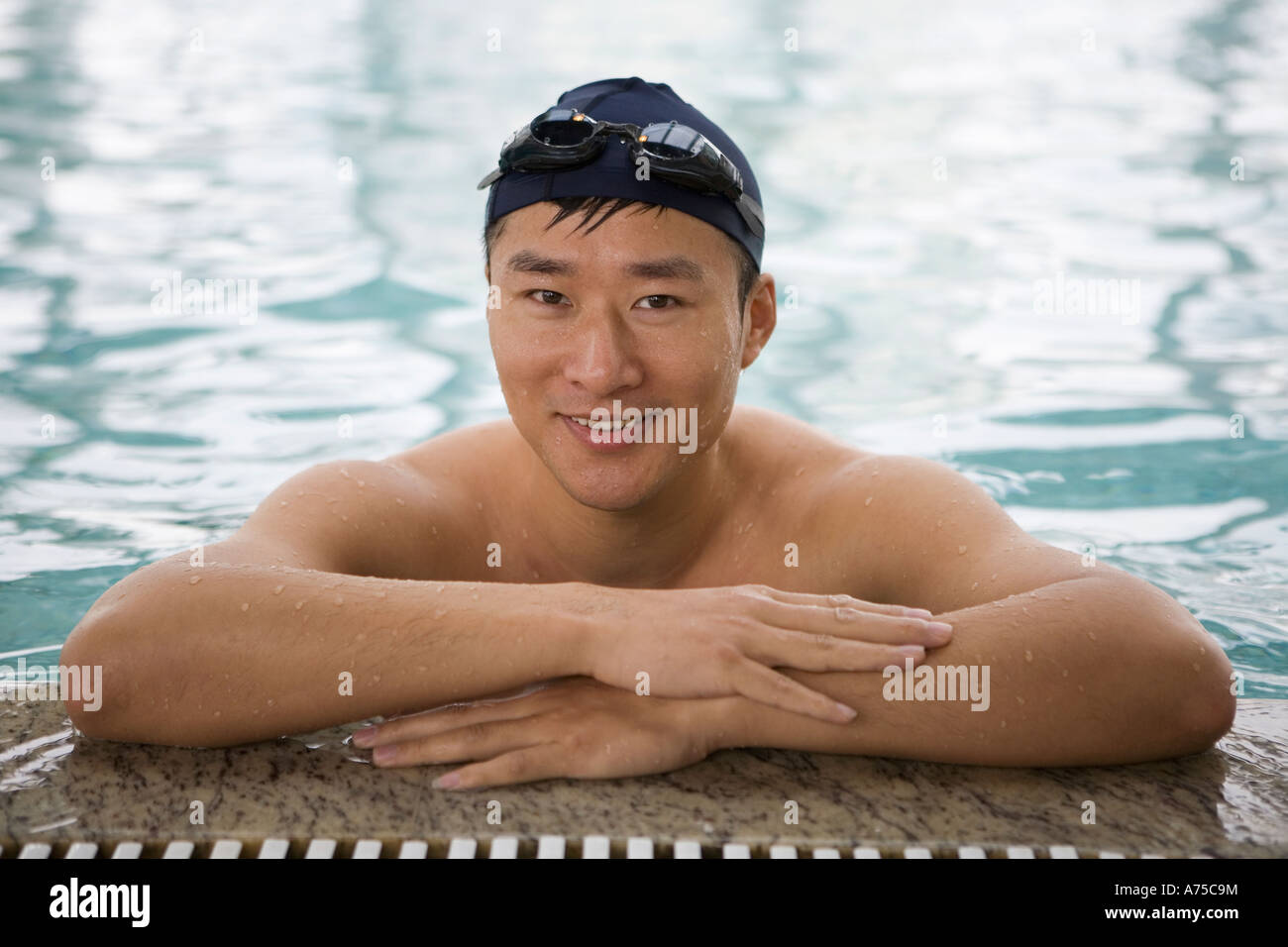 Man leaning on edge of swimming pool Stock Photo - Alamy