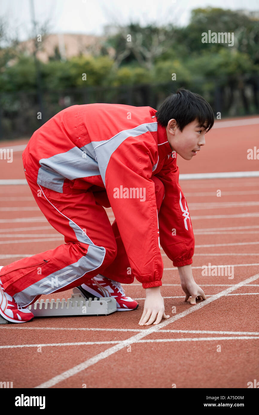 Teenage boy in running position Stock Photo - Alamy