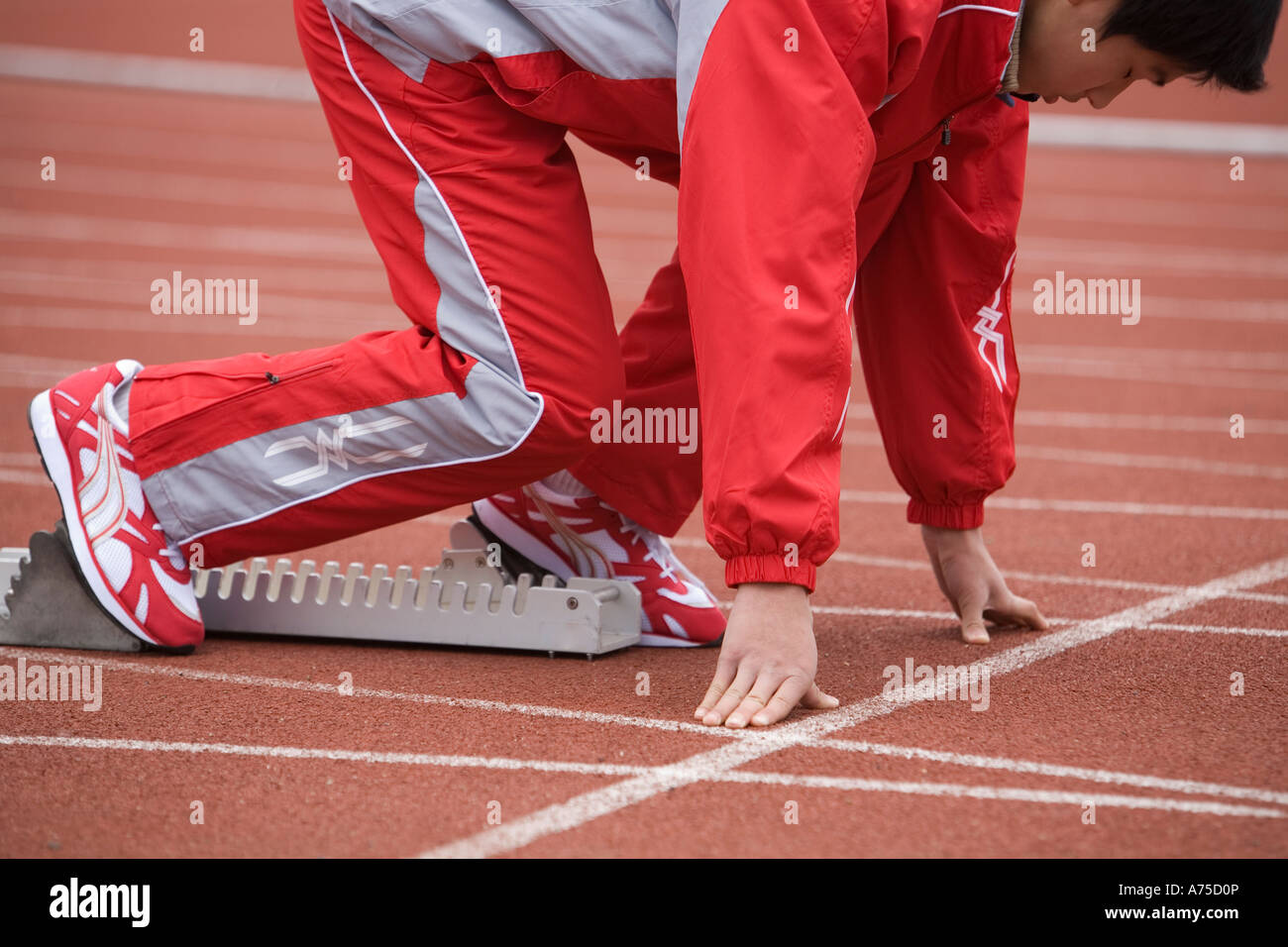 Young boy in running position Stock Photo - Alamy
