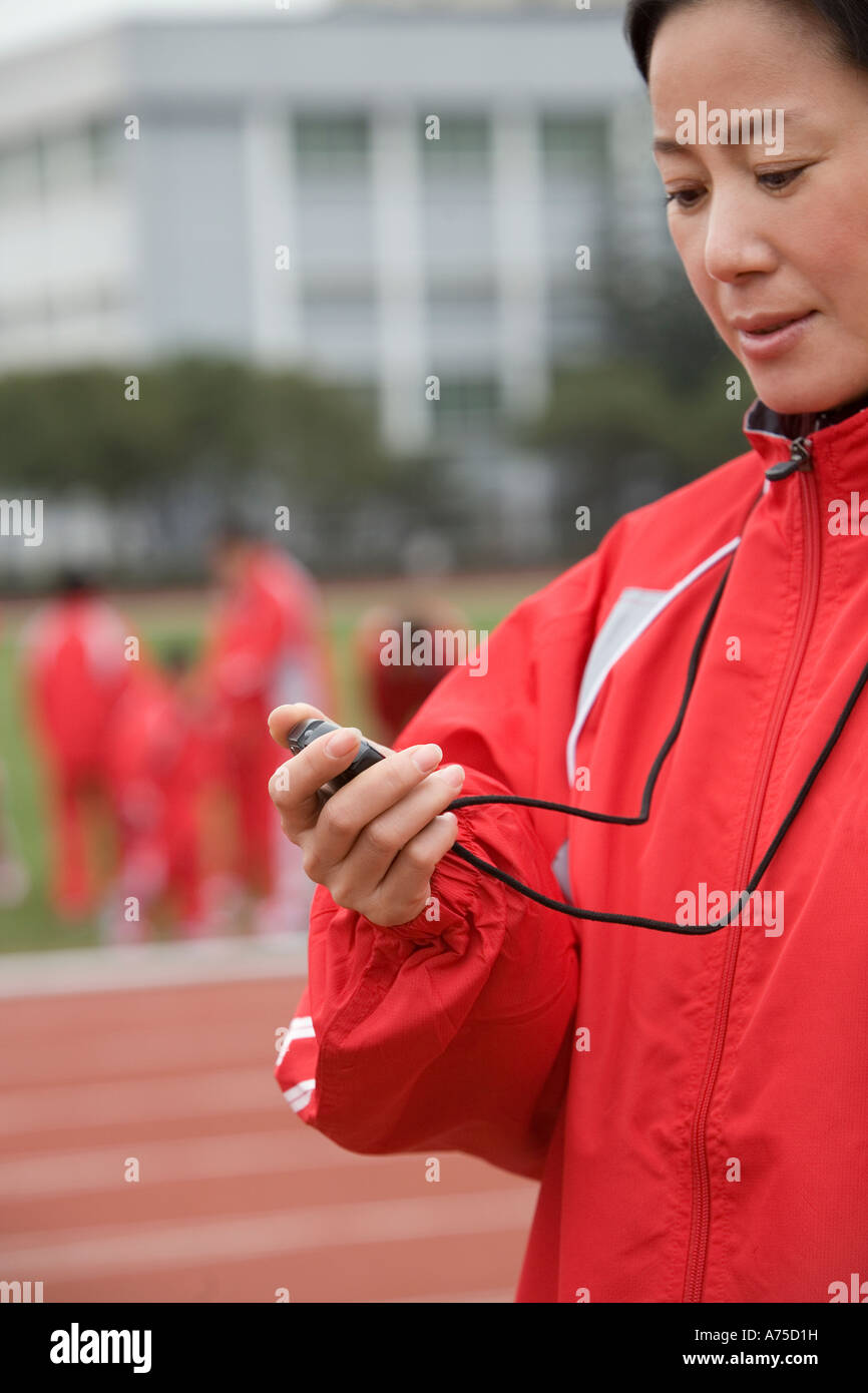 Female athletic coach using stopwatch Stock Photo - Alamy