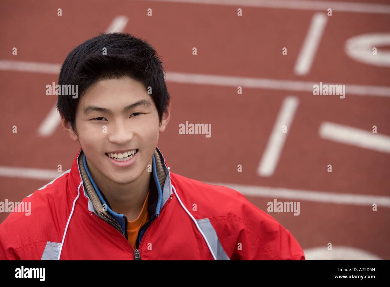 Teenage boy standing on track Stock Photo - Alamy