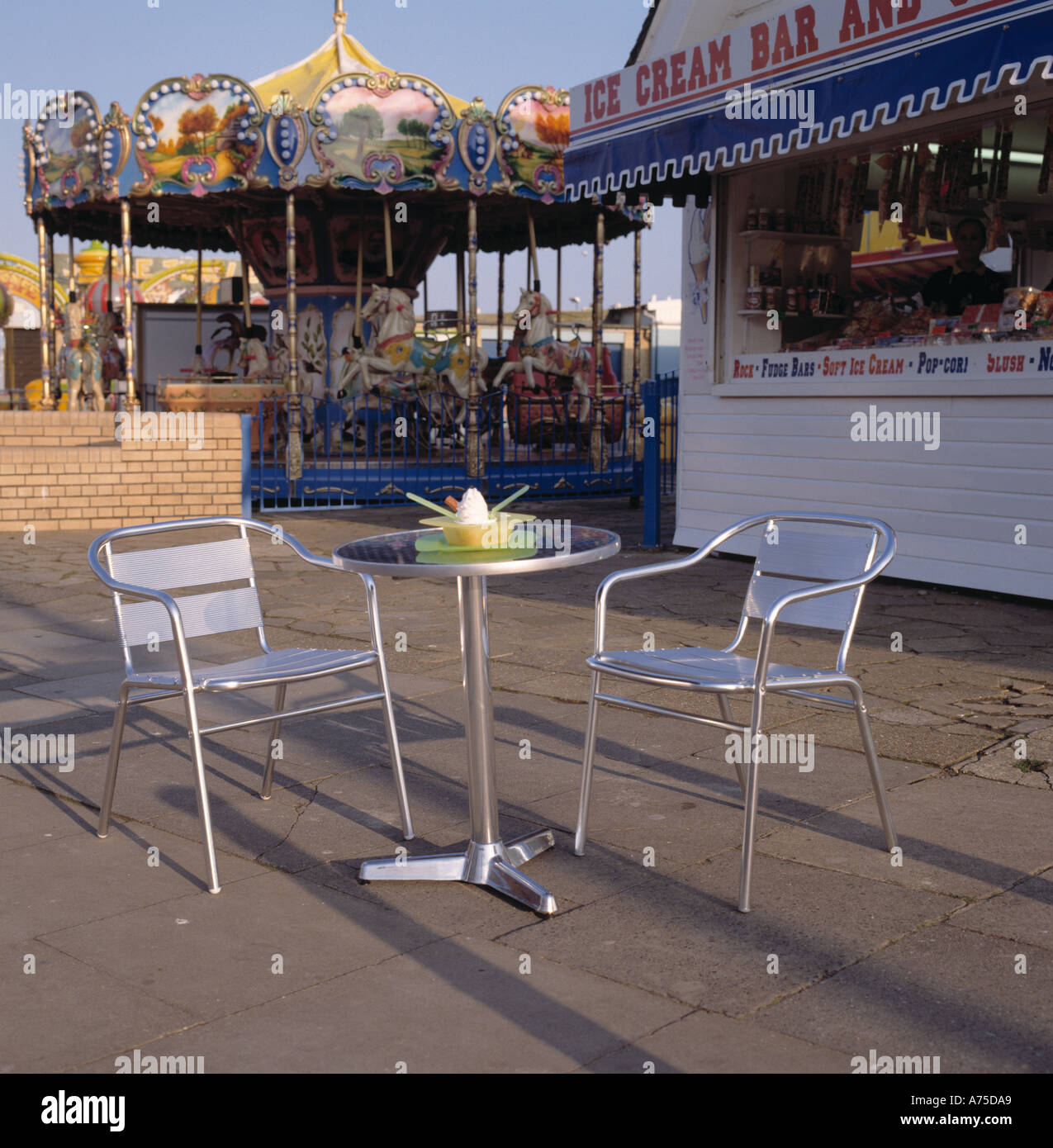 Metal chairs and bistro table outside ice cream bar with old-fashioned ...