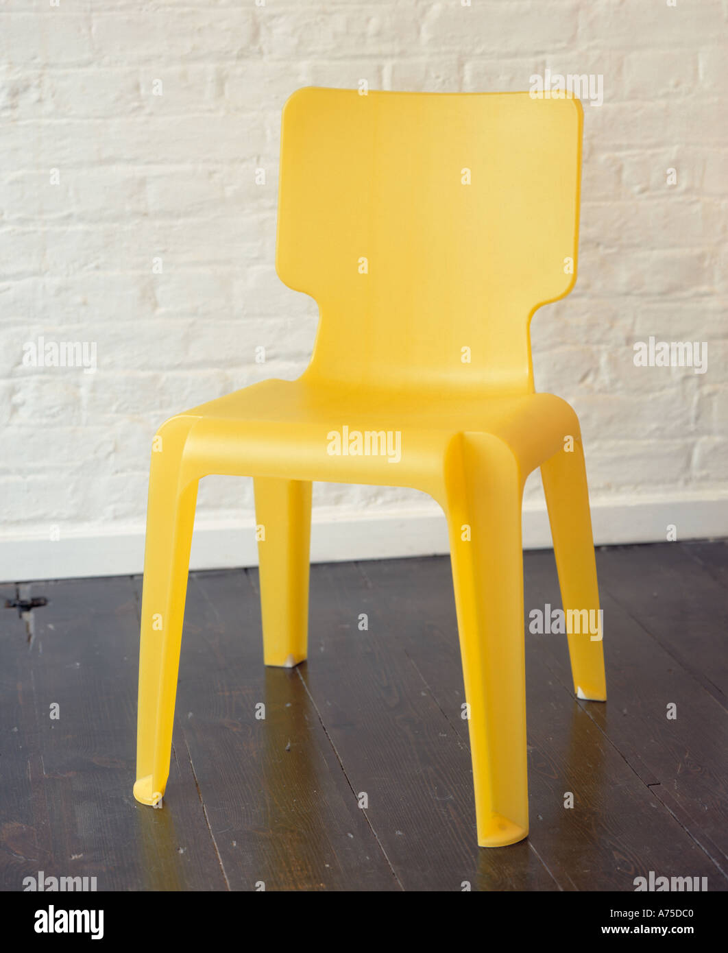 Close-up of yellow plastic Matthew Hilton "Wait" chair Stock Photo - Alamy