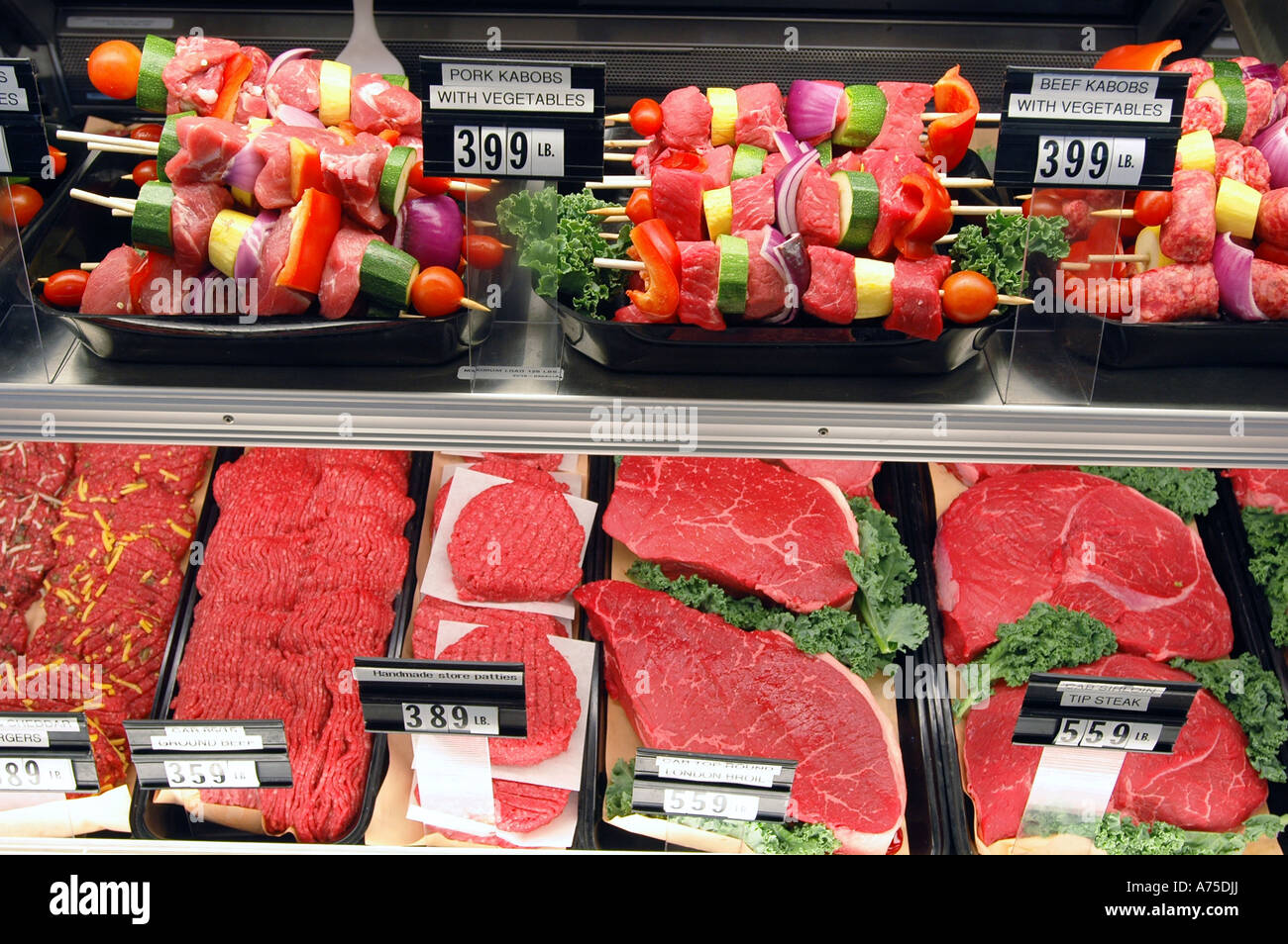 A selection of fresh red meats for sale in a supermarket including ...