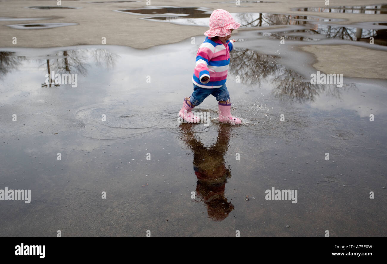 Child playing in puddle of rain water Stock Photo - Alamy