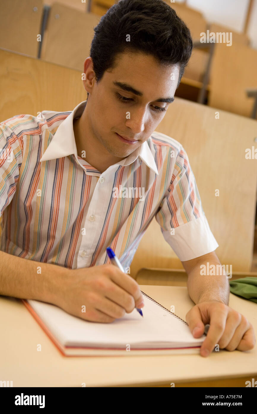 Male student taking notes in class Stock Photo - Alamy