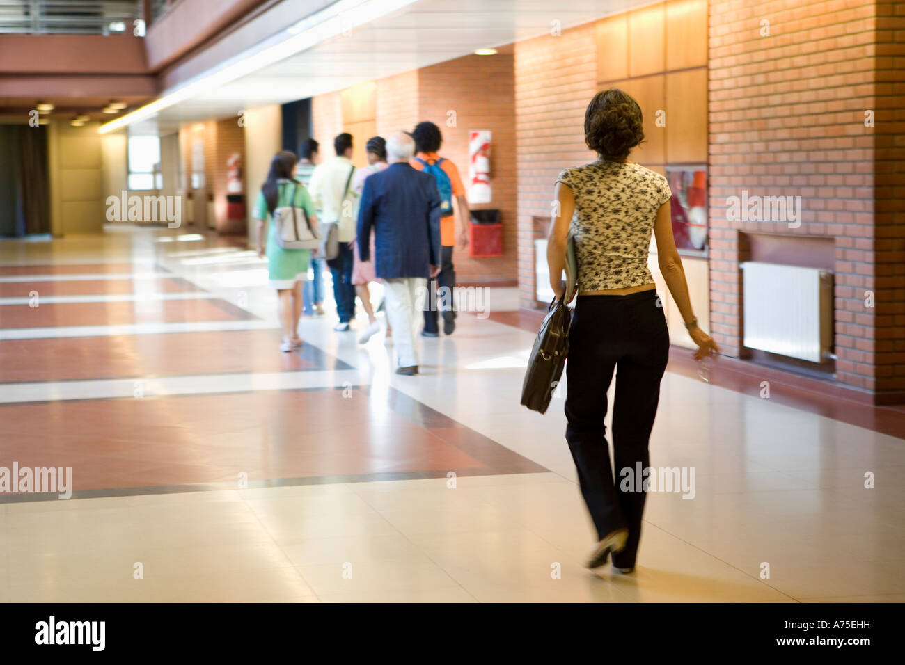 Woman walking through corridor Stock Photo - Alamy