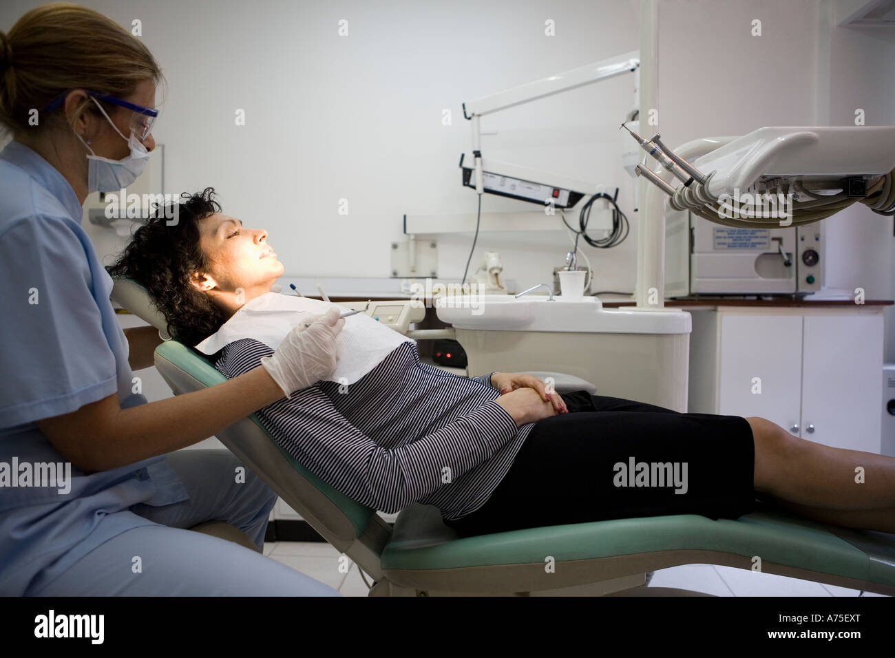 Dentist examining woman's teeth Stock Photo - Alamy