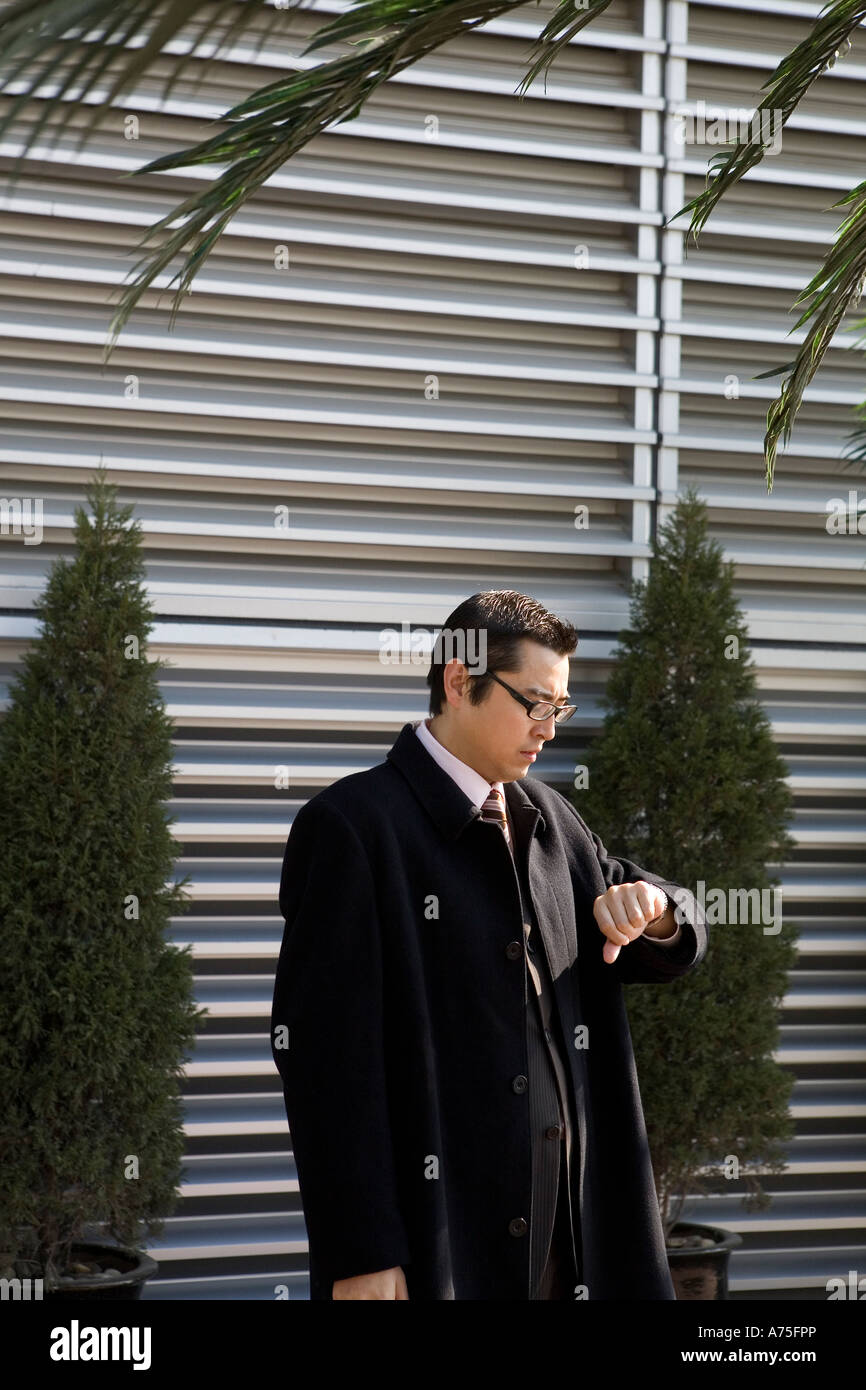Businessman checking his watch outdoors Stock Photo - Alamy