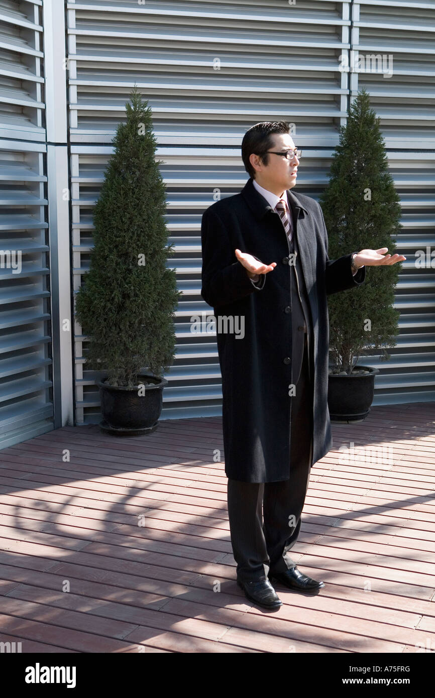 Businessman shrugging outdoors Stock Photo - Alamy