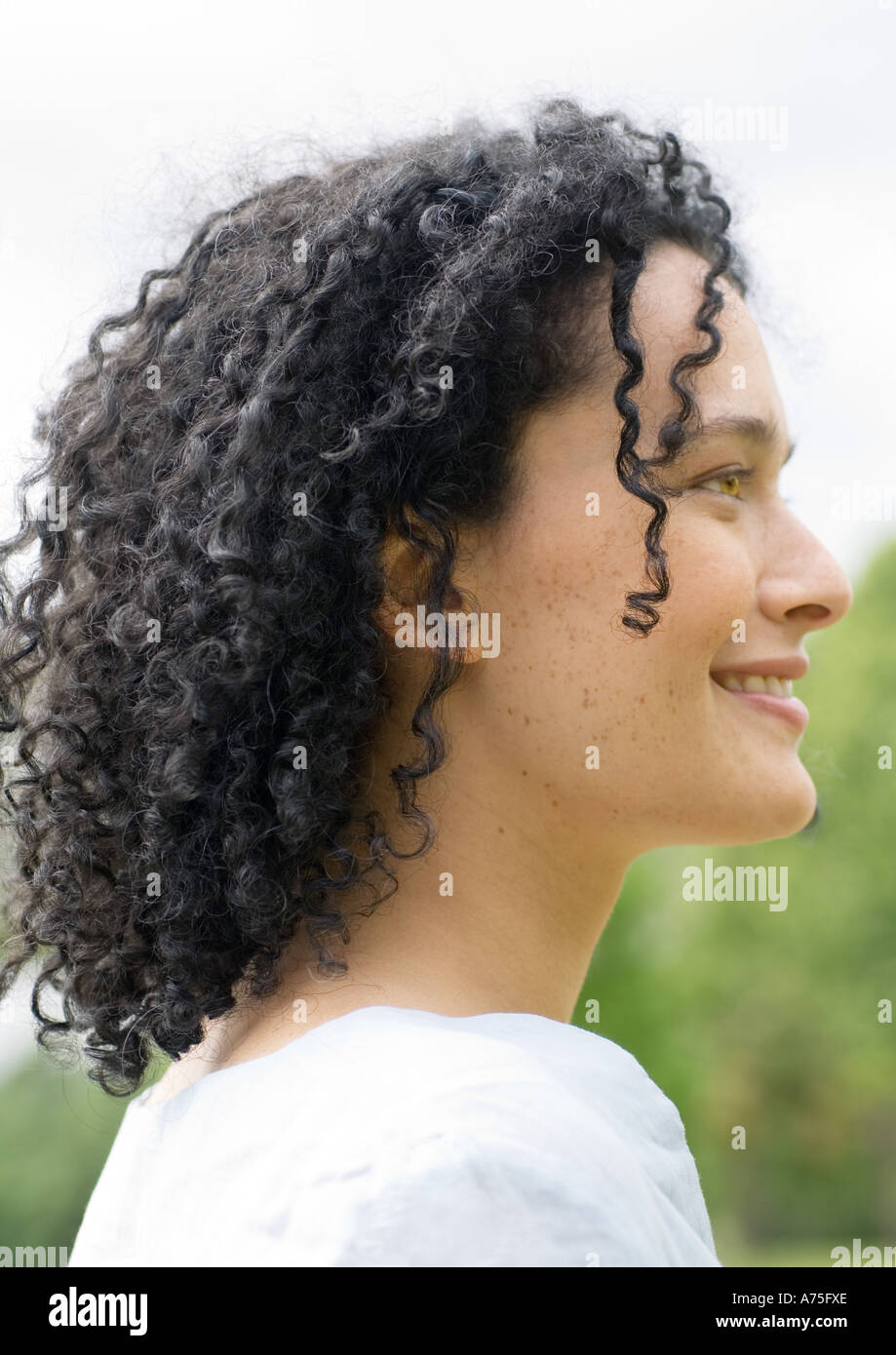 Young woman smiling, side view, portrait Stock Photo - Alamy