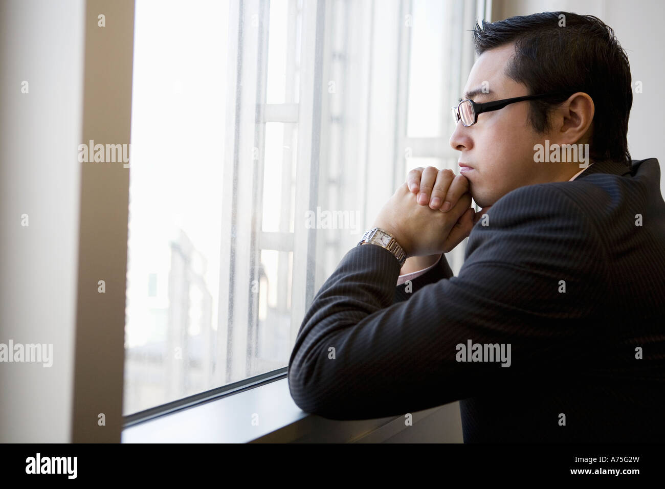 Businessman looking out window Stock Photo - Alamy