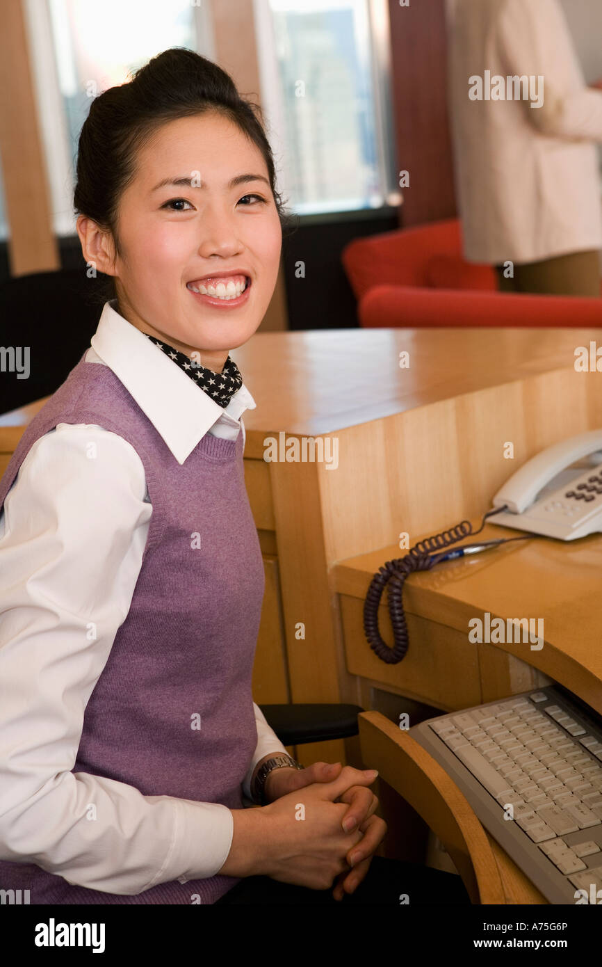 Secretary smiling at her desk Stock Photo - Alamy