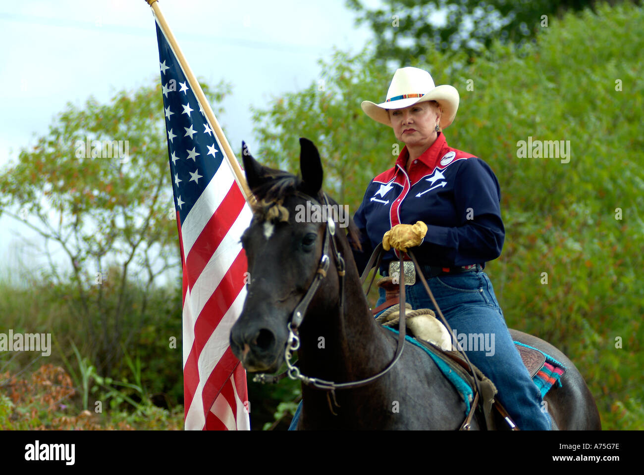 Woman holding an American flag and riding a horse Stock Photo - Alamy