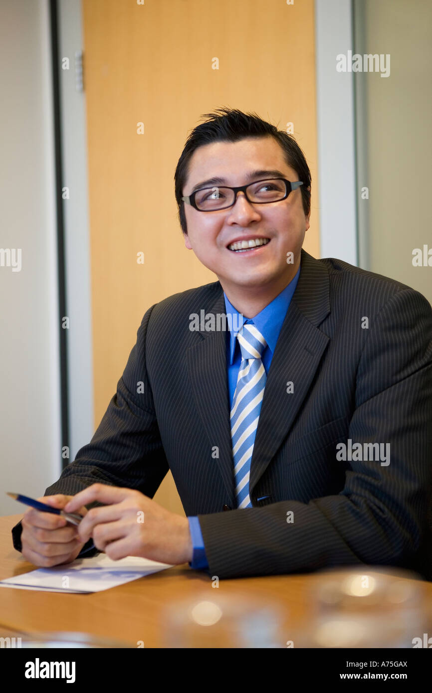 Businessman smiling at his desk Stock Photo - Alamy