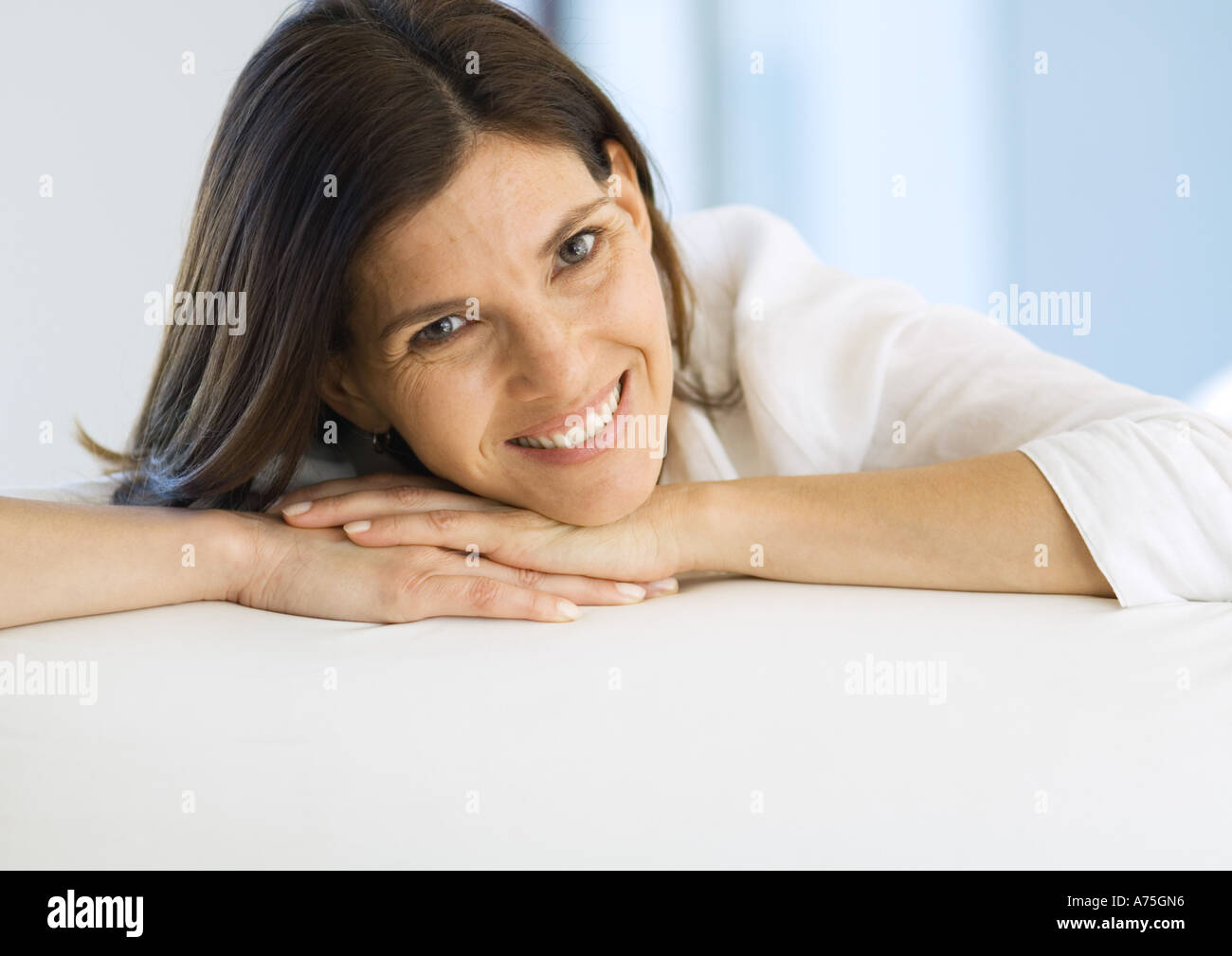Mature woman resting head on hands and smiling, portrait Stock Photo ...
