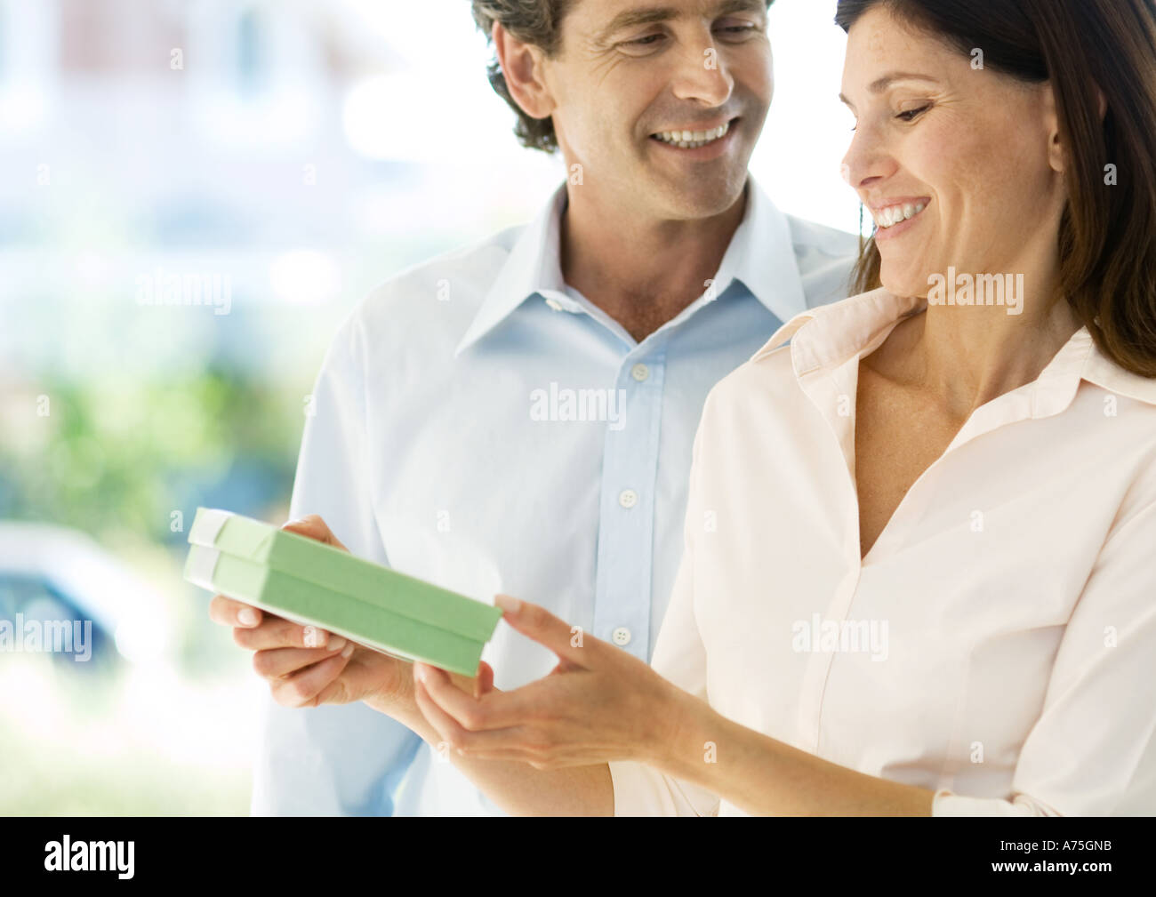 Mature couple, man handing woman gift Stock Photo - Alamy