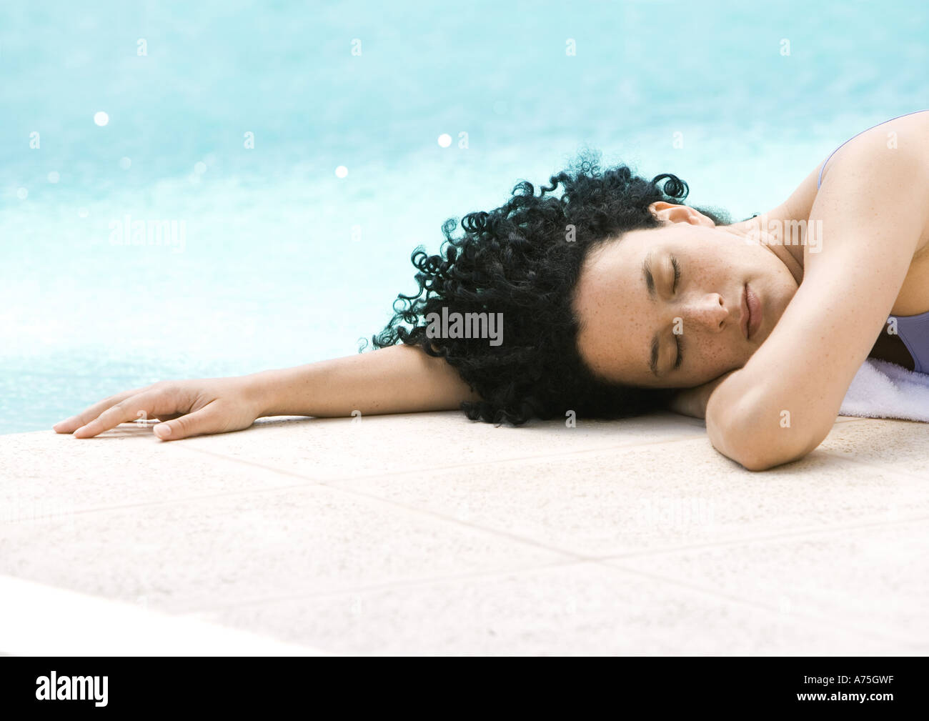 Woman lying down next to swimming pool hi-res stock photography and ...