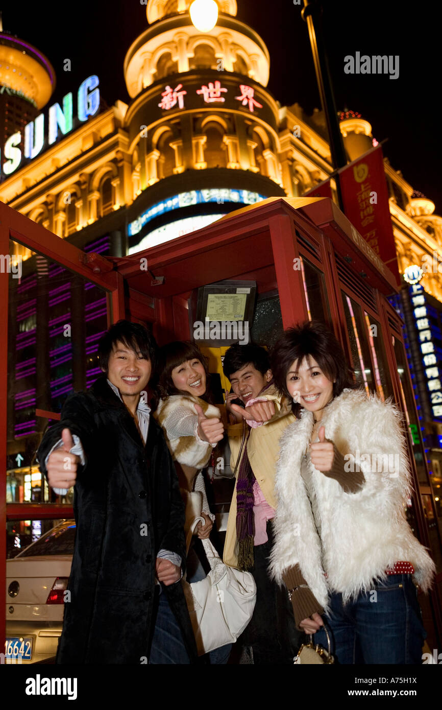 Couples using a payphone amid neon lights Stock Photo - Alamy