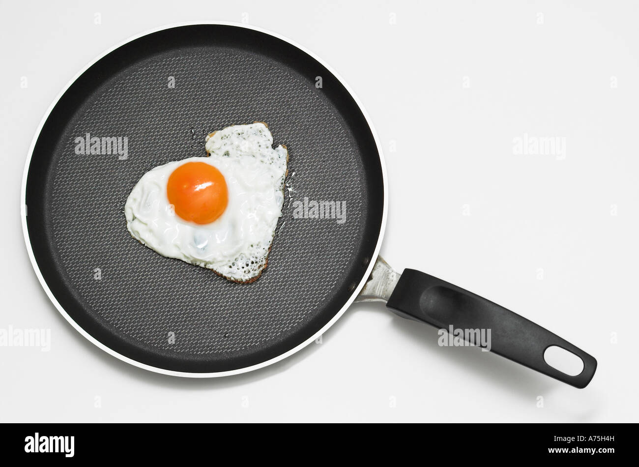 Heart shaped egg in a frying pan Stock Photo - Alamy