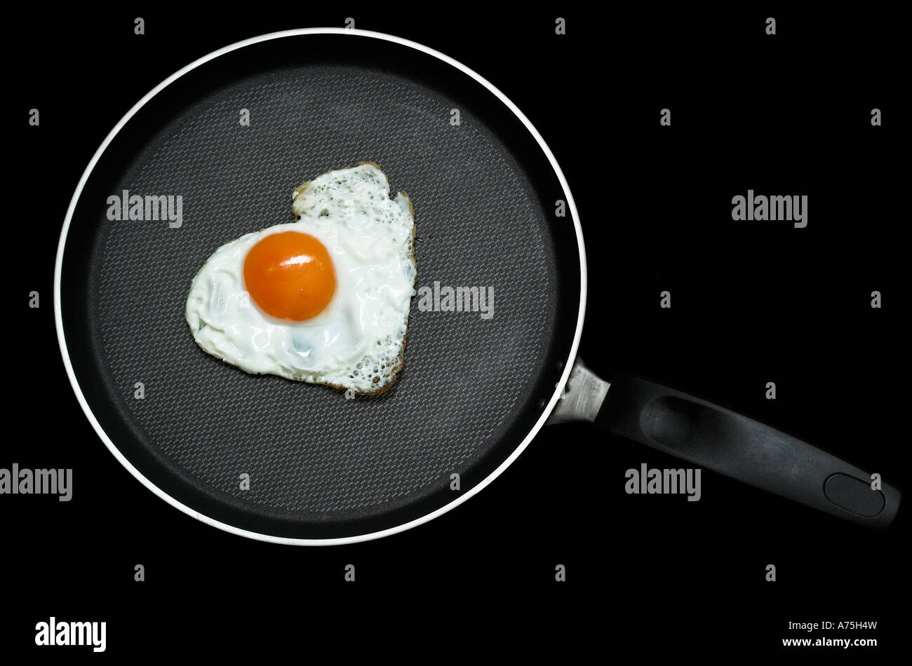 Heart shaped egg in a frying pan Stock Photo - Alamy
