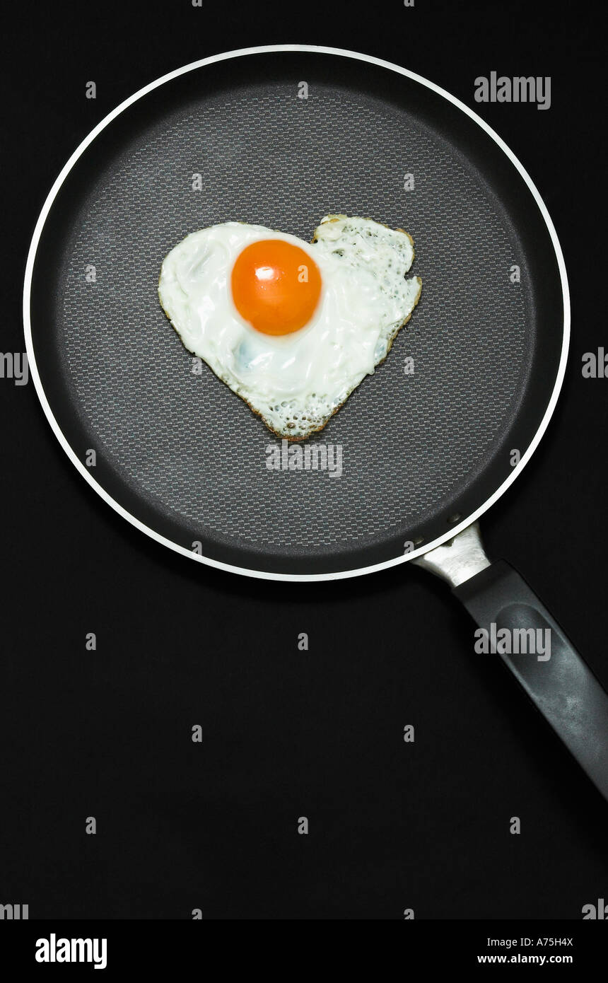 Heart shaped egg in a frying pan Stock Photo - Alamy