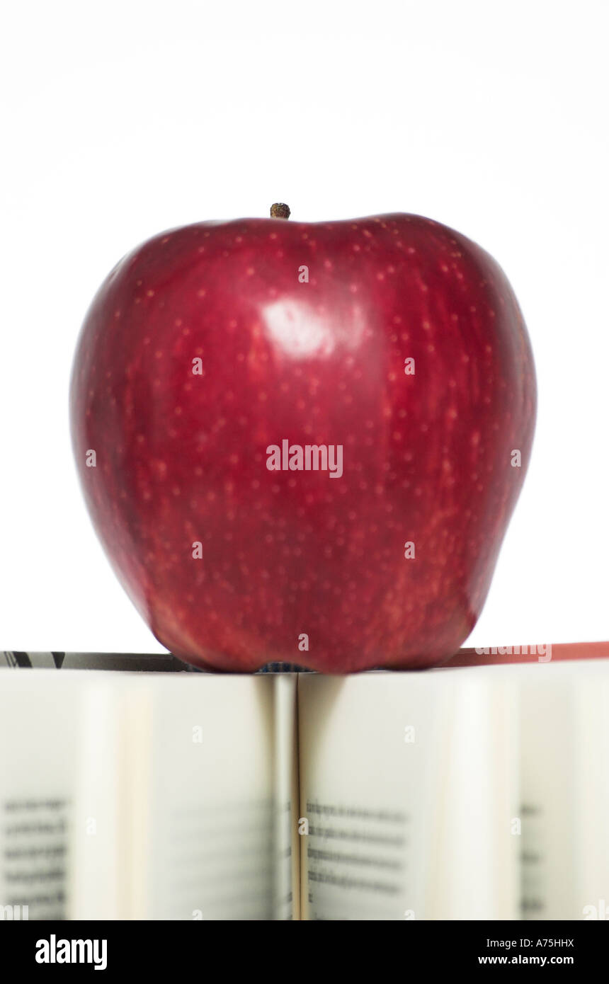 Red apple sitting on open book Stock Photo - Alamy